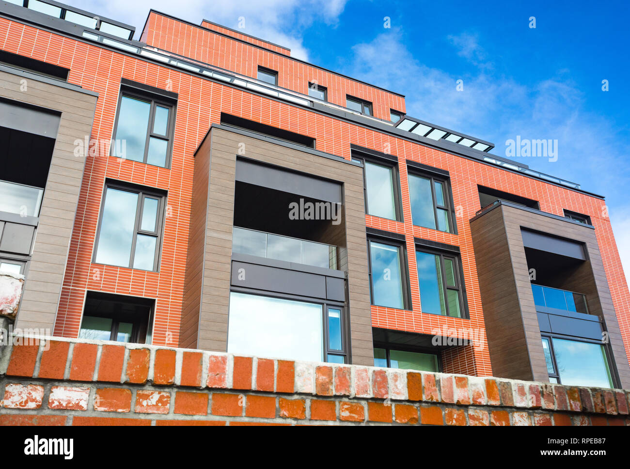 Modern Red Brick Apartment Complex with solid rock fence wall. Home ...