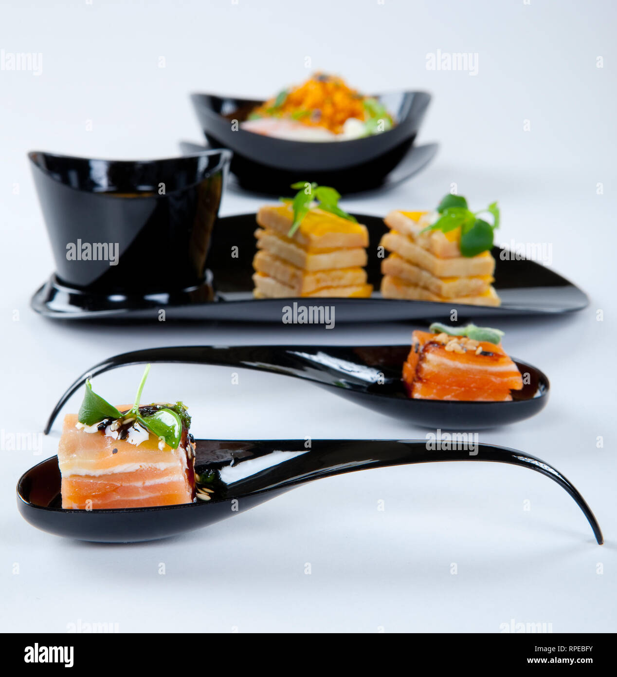 Variety of delicious catering on black dishes and spoons Stock Photo ...