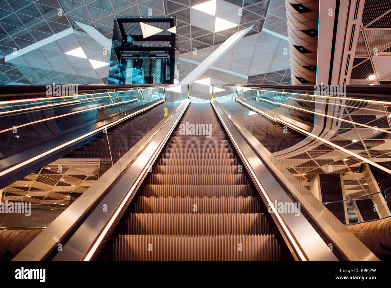 Modern airport terminal escalator up to the departures area. Waiting ...