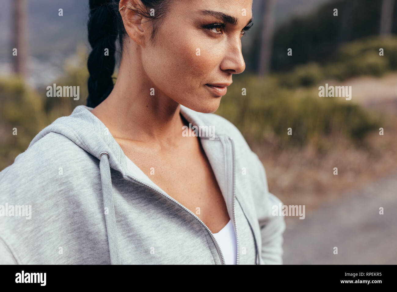 Healthy young female runner standing outdoors in morning. Woman in ...