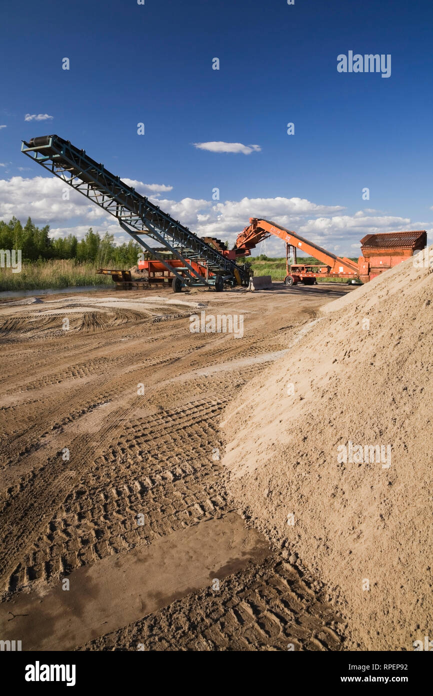 Stacking conveyor and a screener next to a mound of sand in a ...