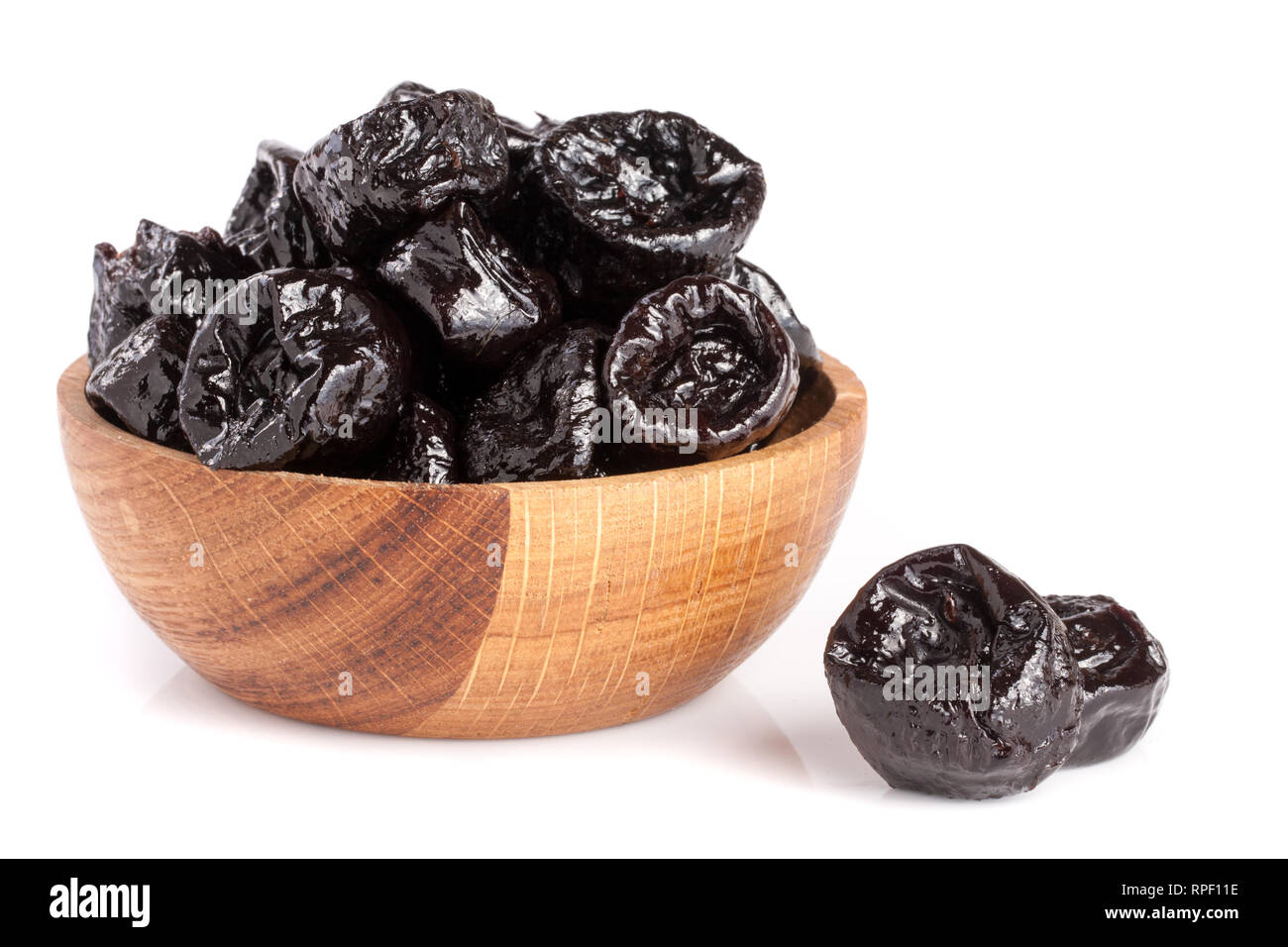 Dried plums or prunes in wooden bowl isolated on white background Stock ...