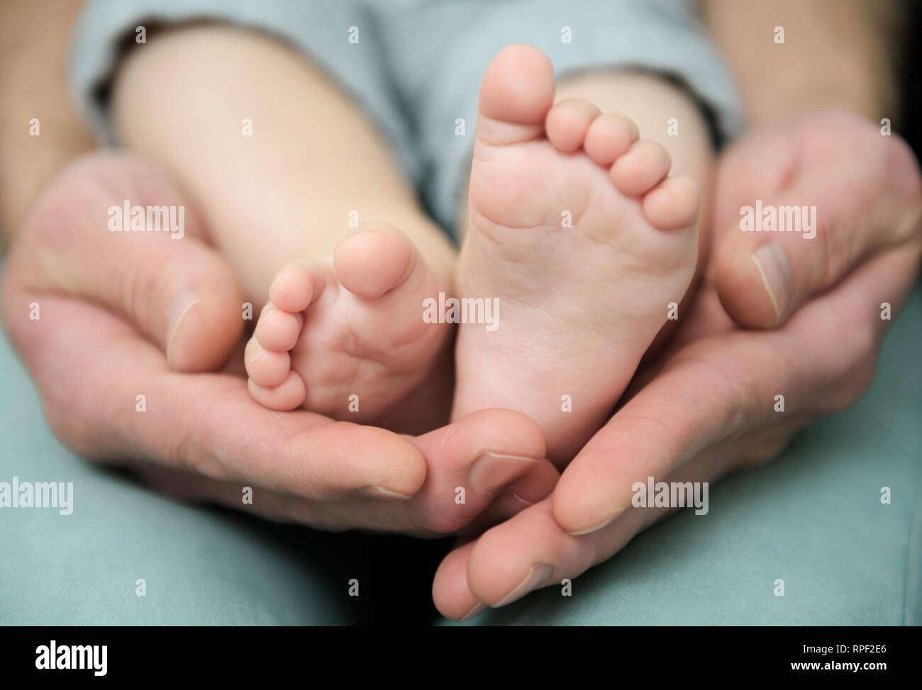Hands holding baby feet hi-res stock photography and images - Alamy