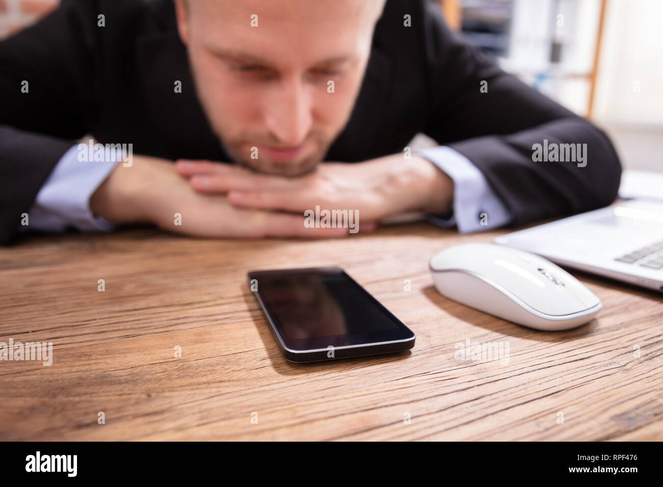 Happy Businessman Waiting For A Call On Cellphone In Office Stock Photo ...