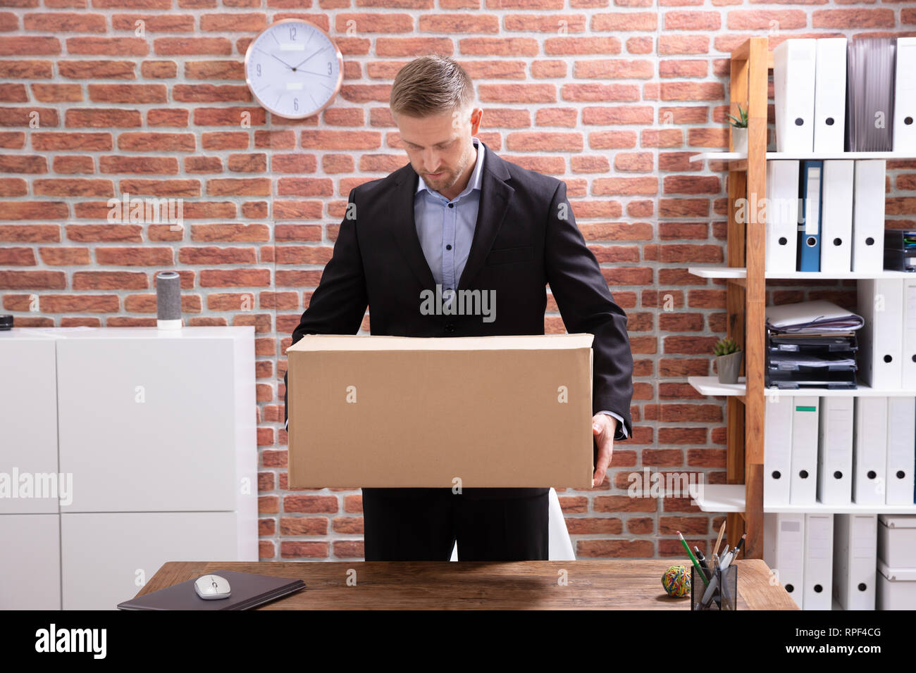 Young Businessman Packing His Belongings In Cardboard Box At Workplace ...