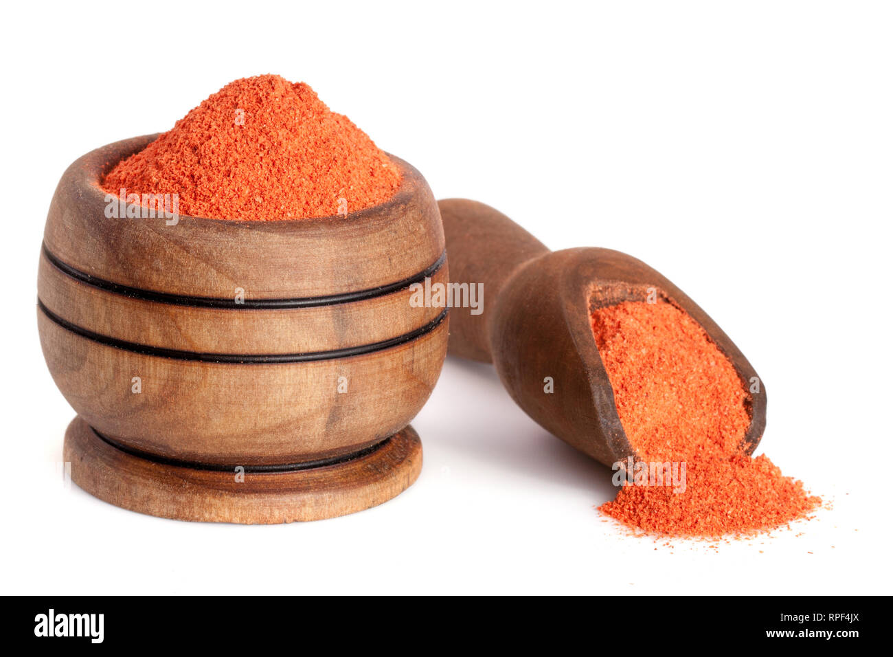 Ground paprika in a wooden bowl with a scoop isolated on a white ...