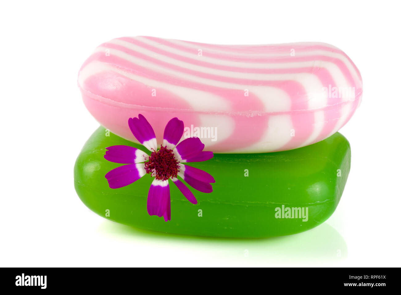 Two multi-colored striped soaps with a flower isolated on white ...