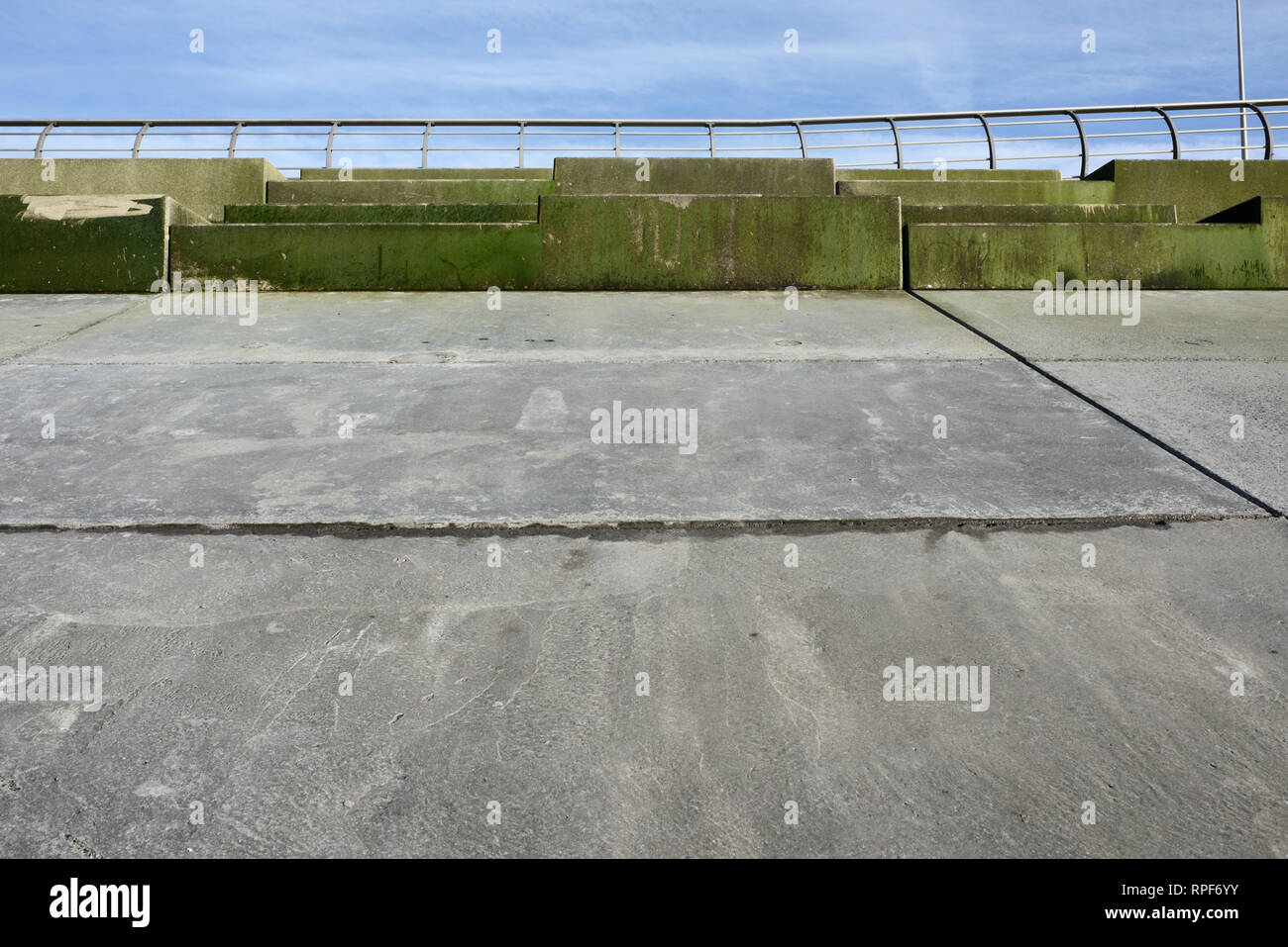 Sloping revetment and sea wall with pedestrian guard railing, part of ...