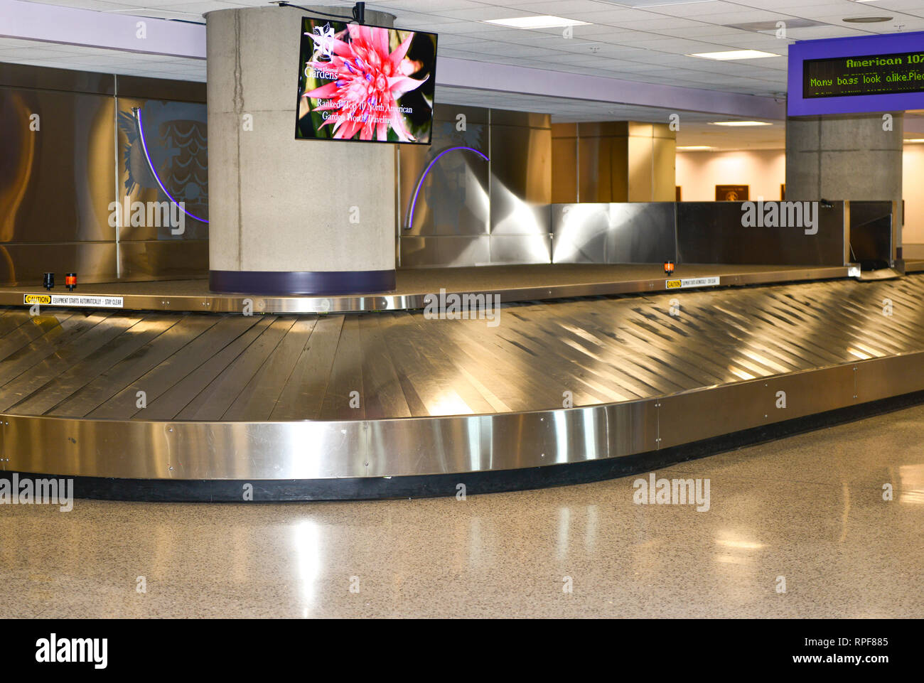 An empty baggage claim area with advertising on TV Screen at the Tucson ...