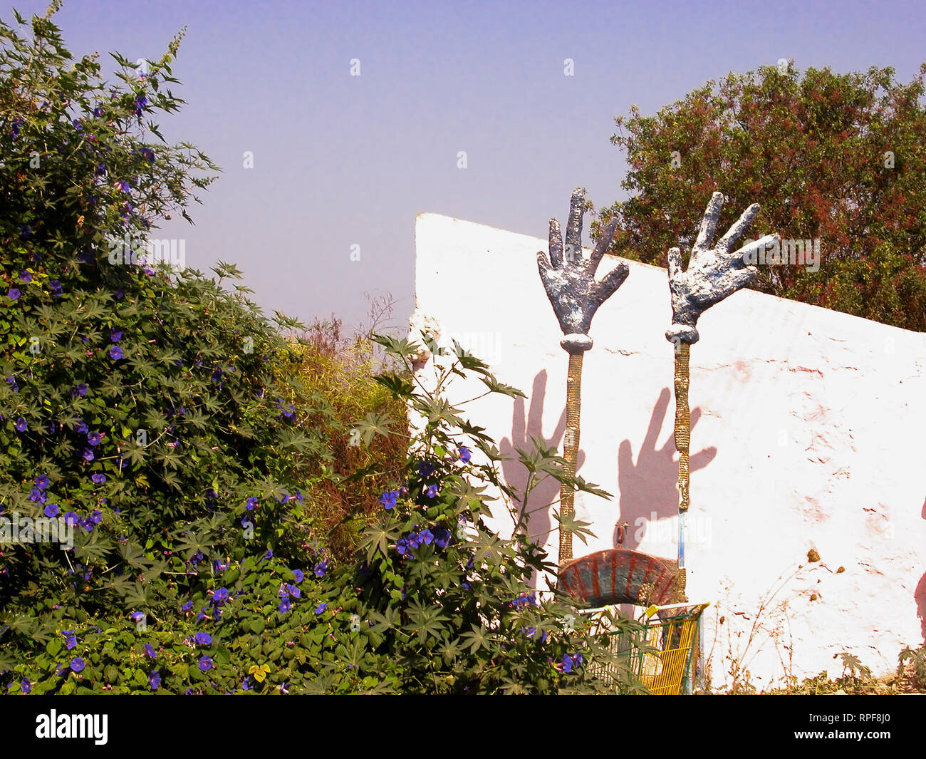 Eccentric sculpture of a pair of hands by a white wall and morning ...