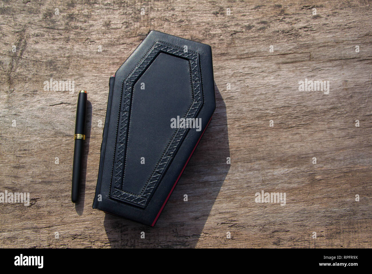 Leather book with cover in shape of Coffin. The book is captured closed ...