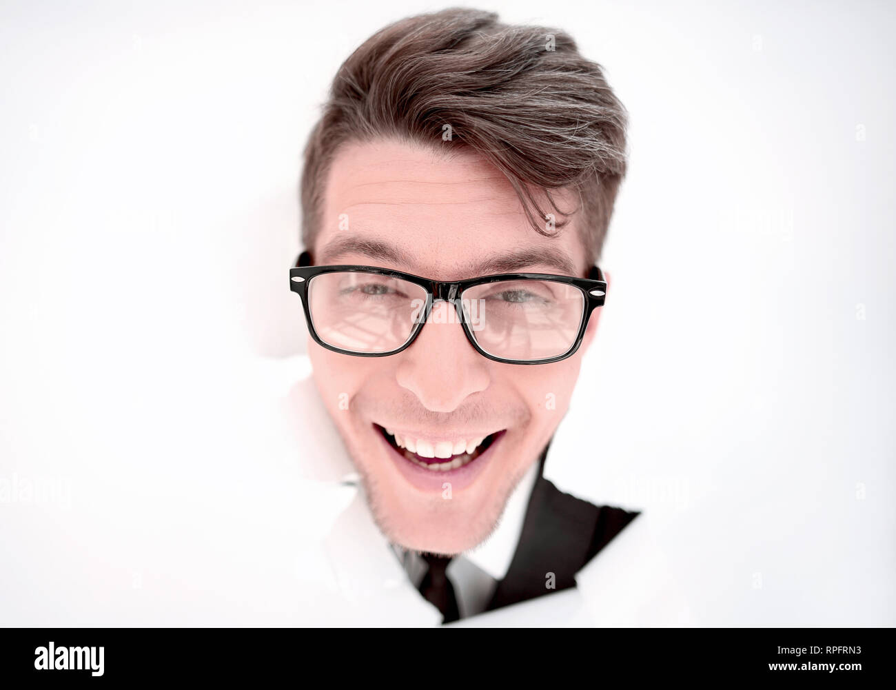 young businessman breaking through a white paper wall Stock Photo - Alamy