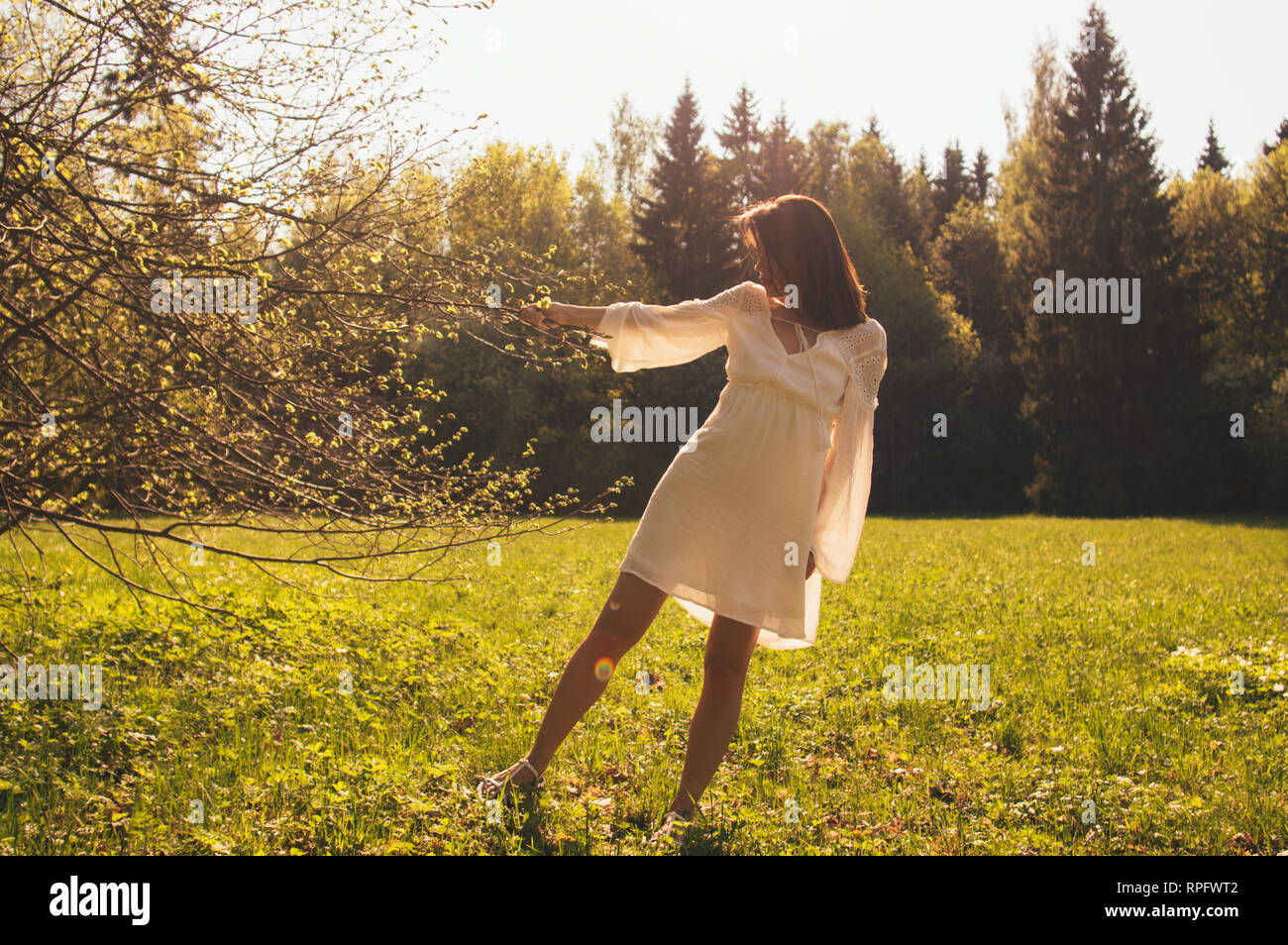 Beautiful brunette girl posing in the spring, sunlight Stock Photo - Alamy