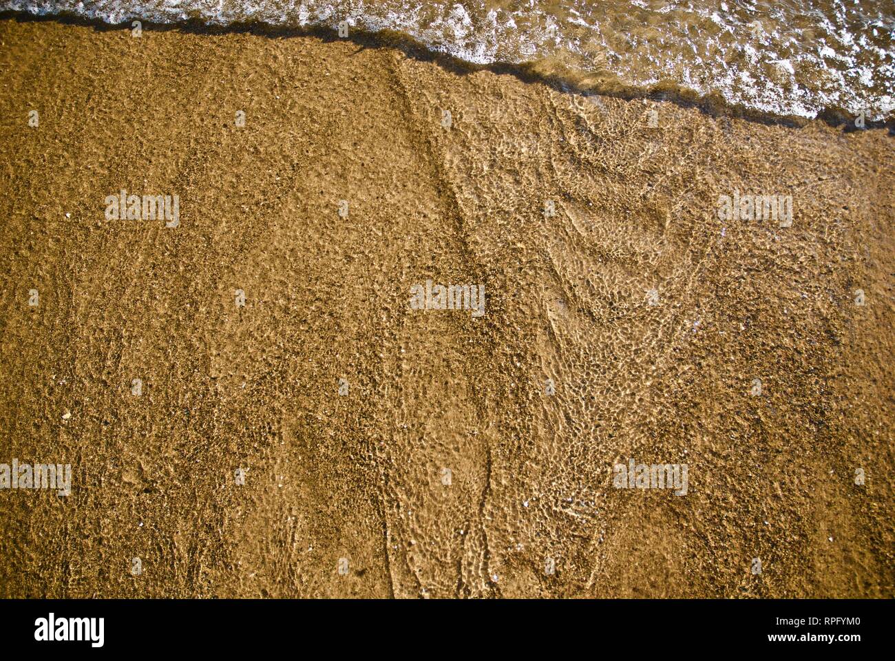 Sea water makes undulating abstract patterns and shapes in brilliant ...