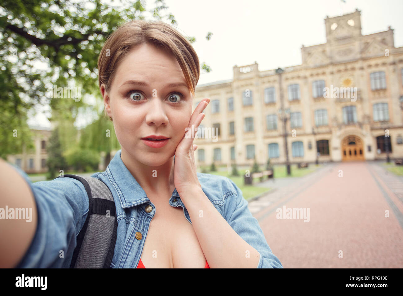 Young student with backpack at university campus standing taking selfie ...