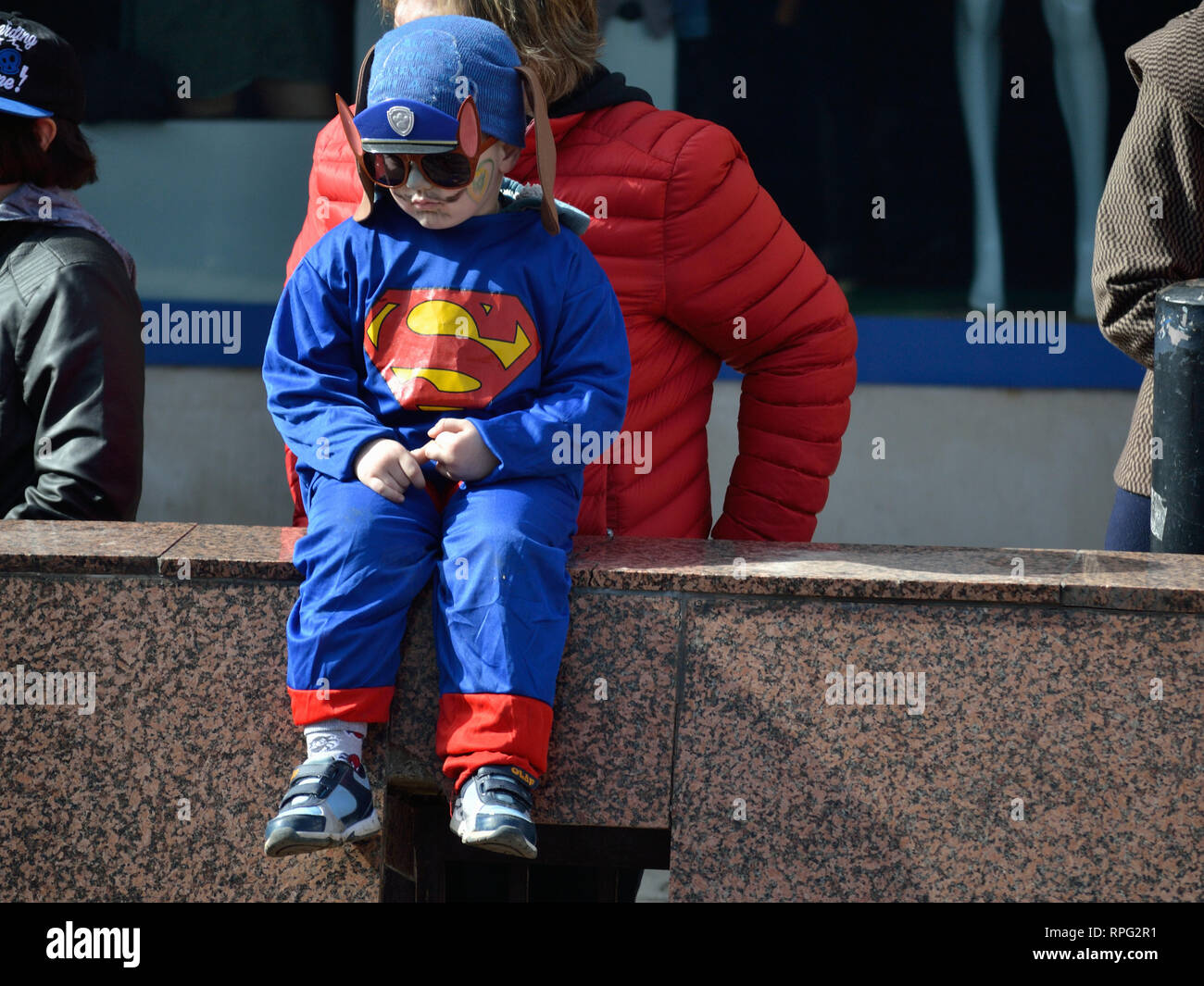 Little boy dressed as superhero, sitting and thinking about something ...