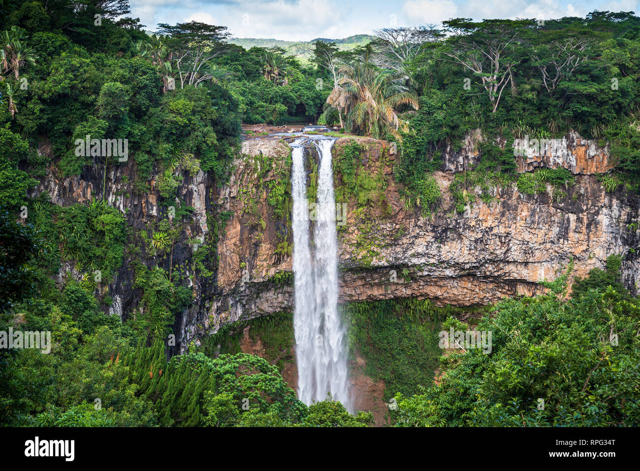 View at Chamarel waterfall water falling from the cliff surrounded by a ...