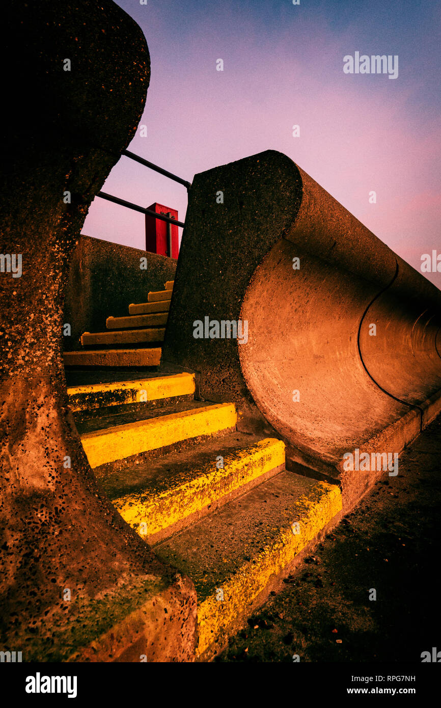Steps through a concrete sea wall at sunrise Stock Photo - Alamy