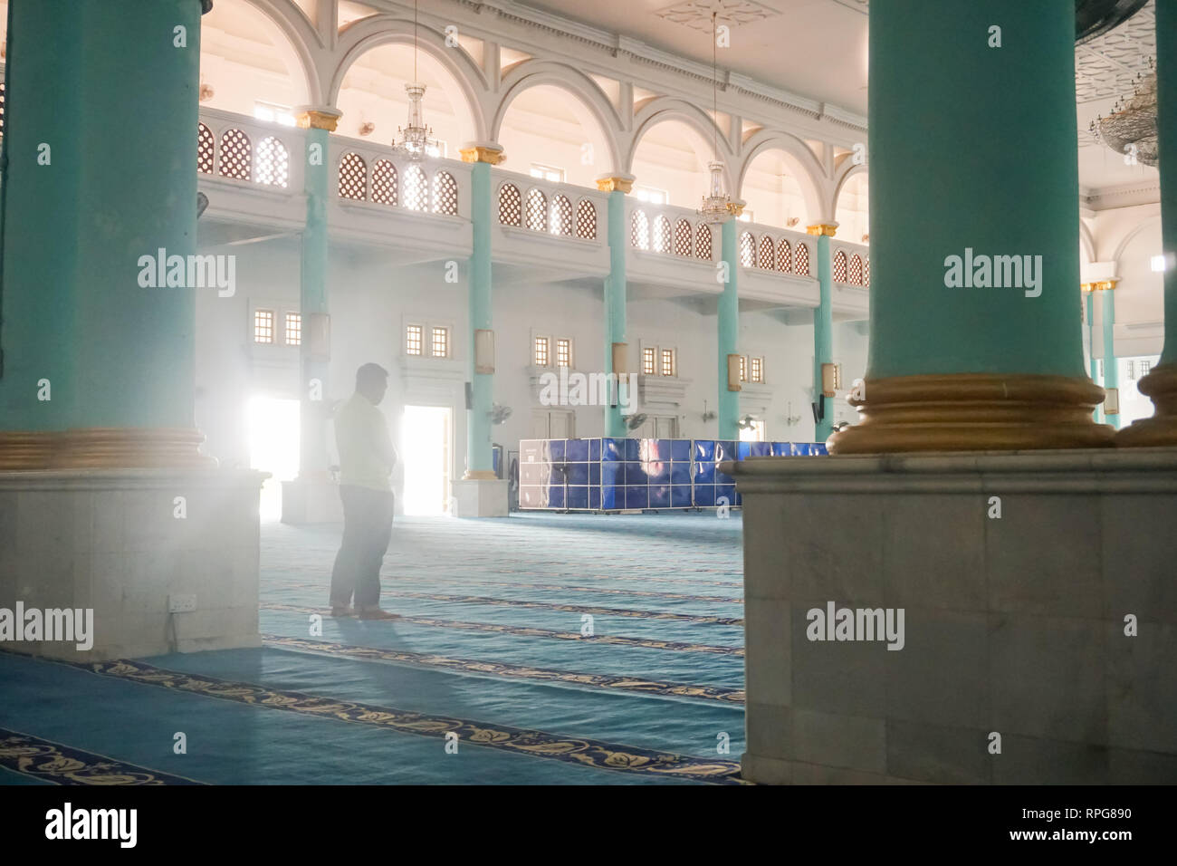 View of man performing prayer in the Blue Mosque of Sultan Ismail ...