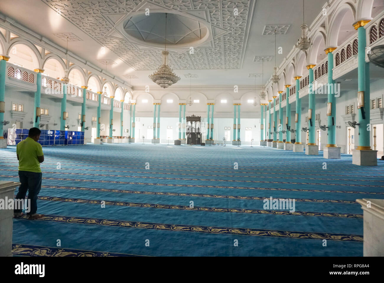 View of man performing prayer in the Blue Mosque of Sultan Ismail ...