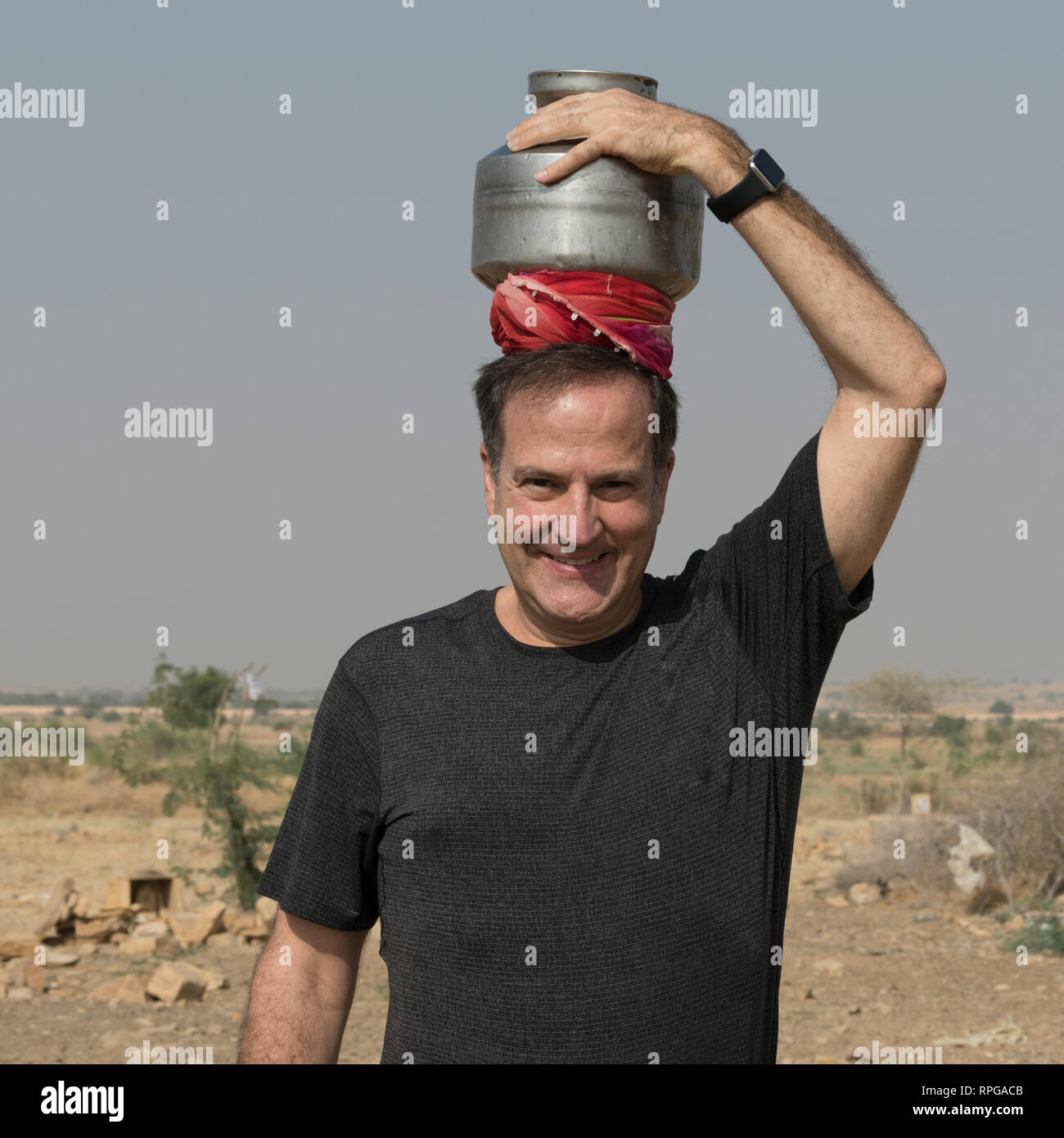 Happy man carrying water pot on his head, Jaisalmer, Rajasthan, India ...