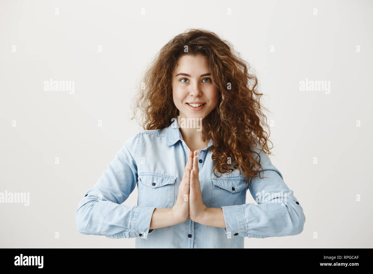 Portrait of a beautiful woman praying, isolated on a gray background ...