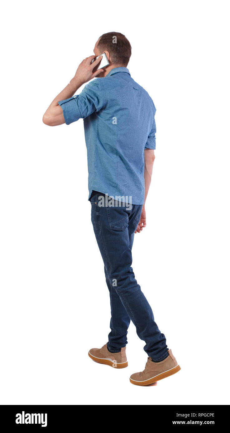 backview of man walking with a mobile phone. backside view of person ...