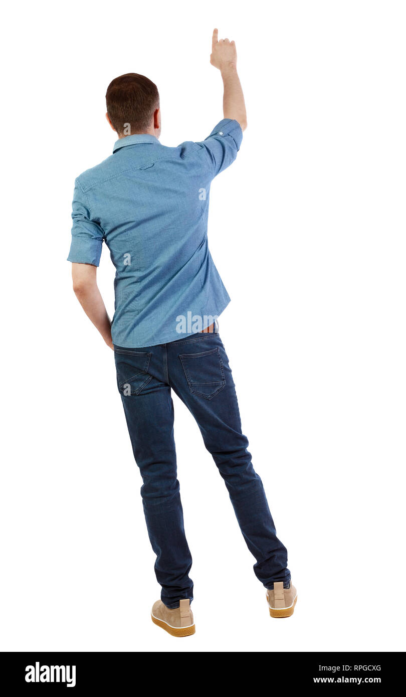 Back view of a man in jeans points his hand upwards. Rear view people ...