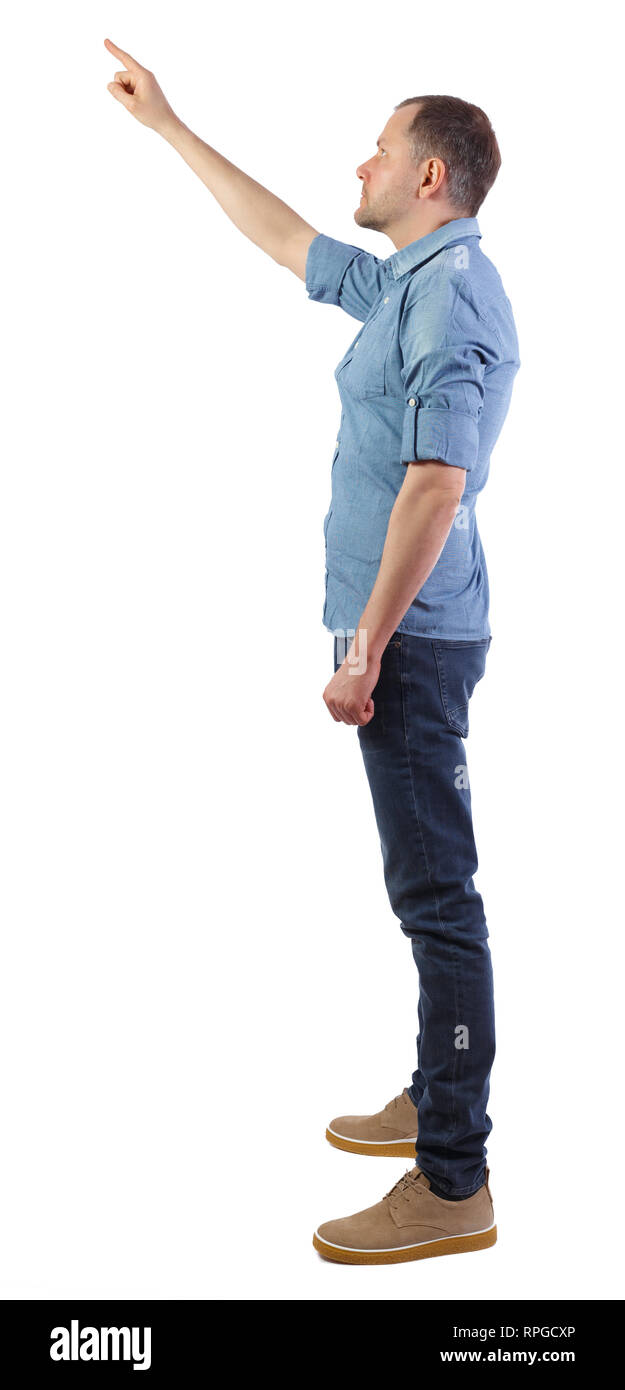 Side view of a man in jeans points his hand upwards. Rear view people ...