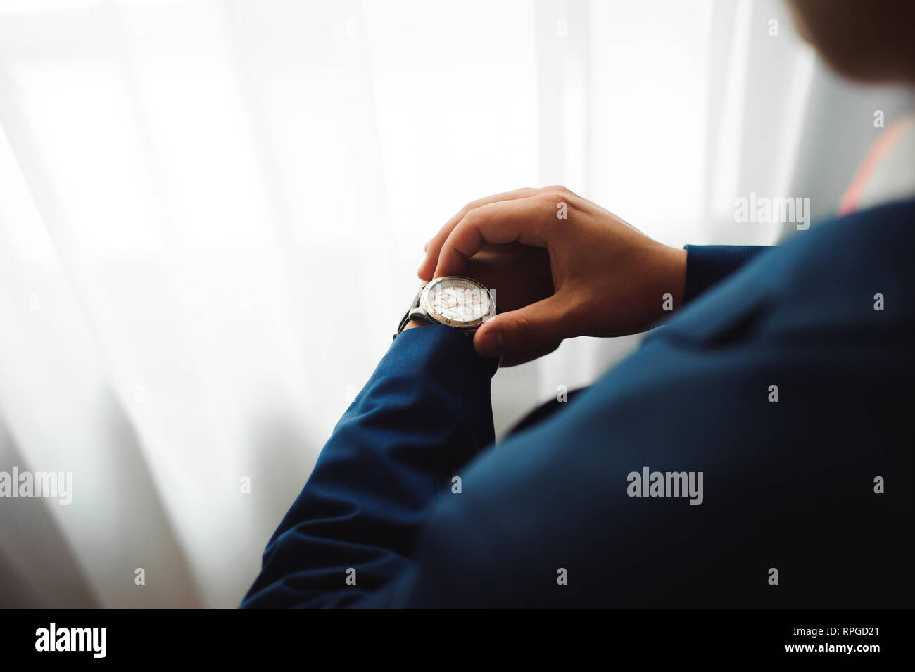 Man checking the time on his wrist watch Stock Photo - Alamy