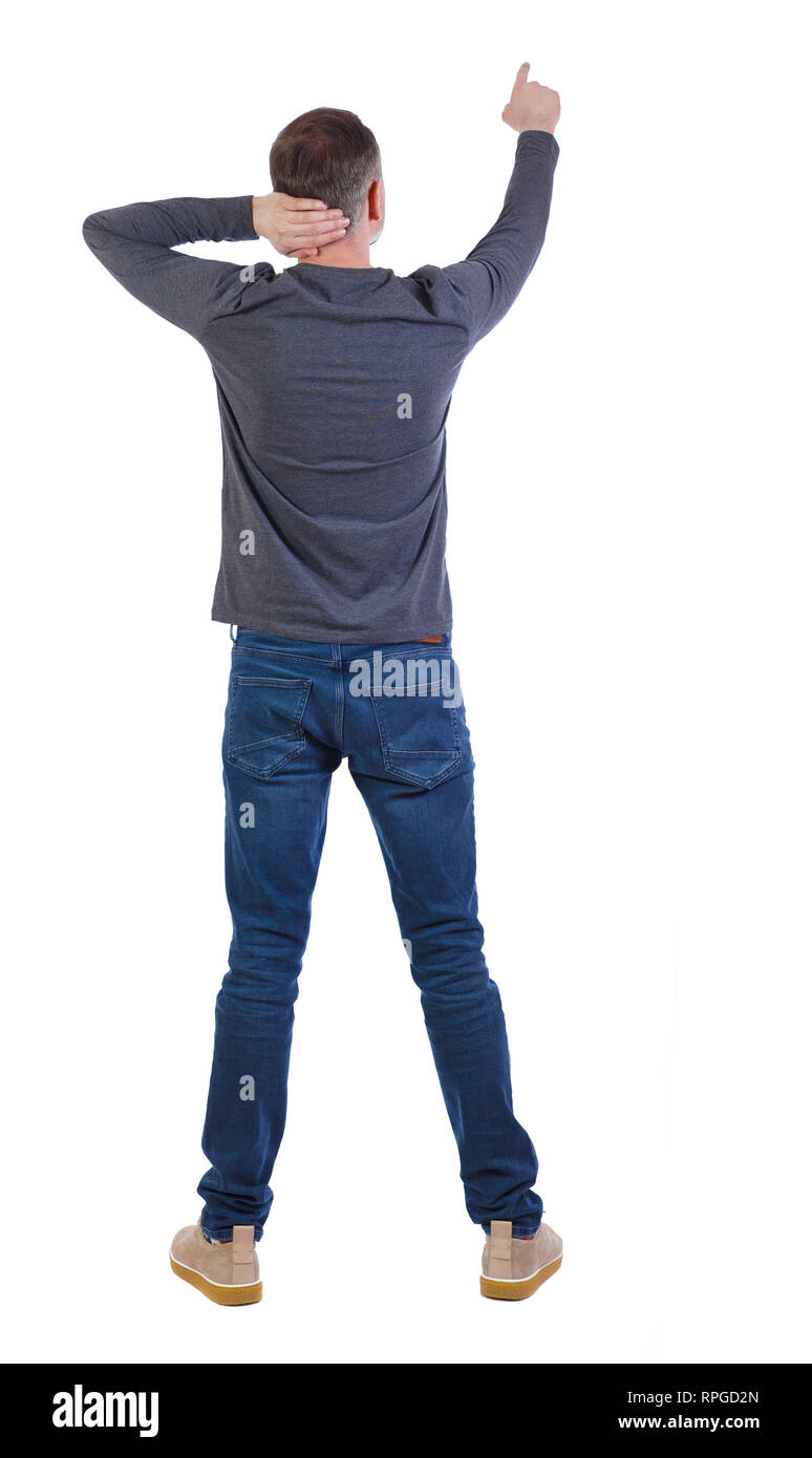 Back view of a man in jeans points his hand upwards. Rear view people ...