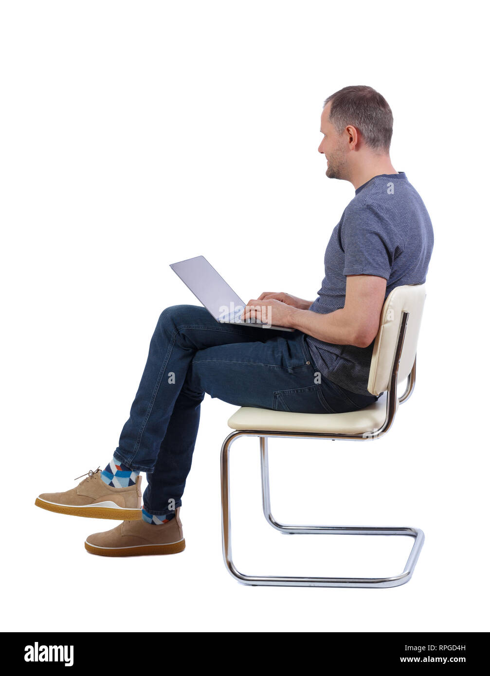 Side view of a man who sits on a chair with a laptop. Rear view people ...