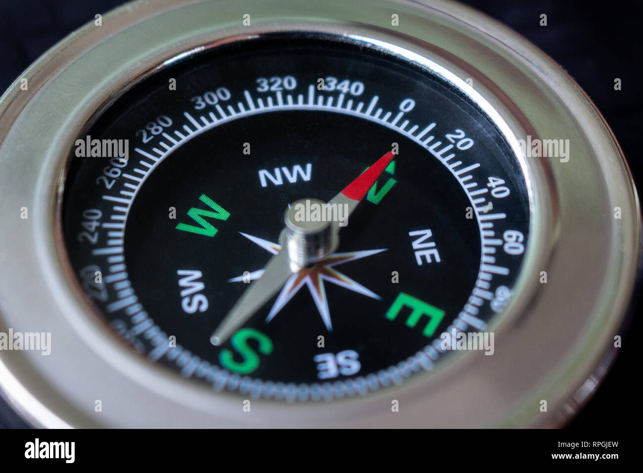 Macro focus compass on black background Stock Photo - Alamy