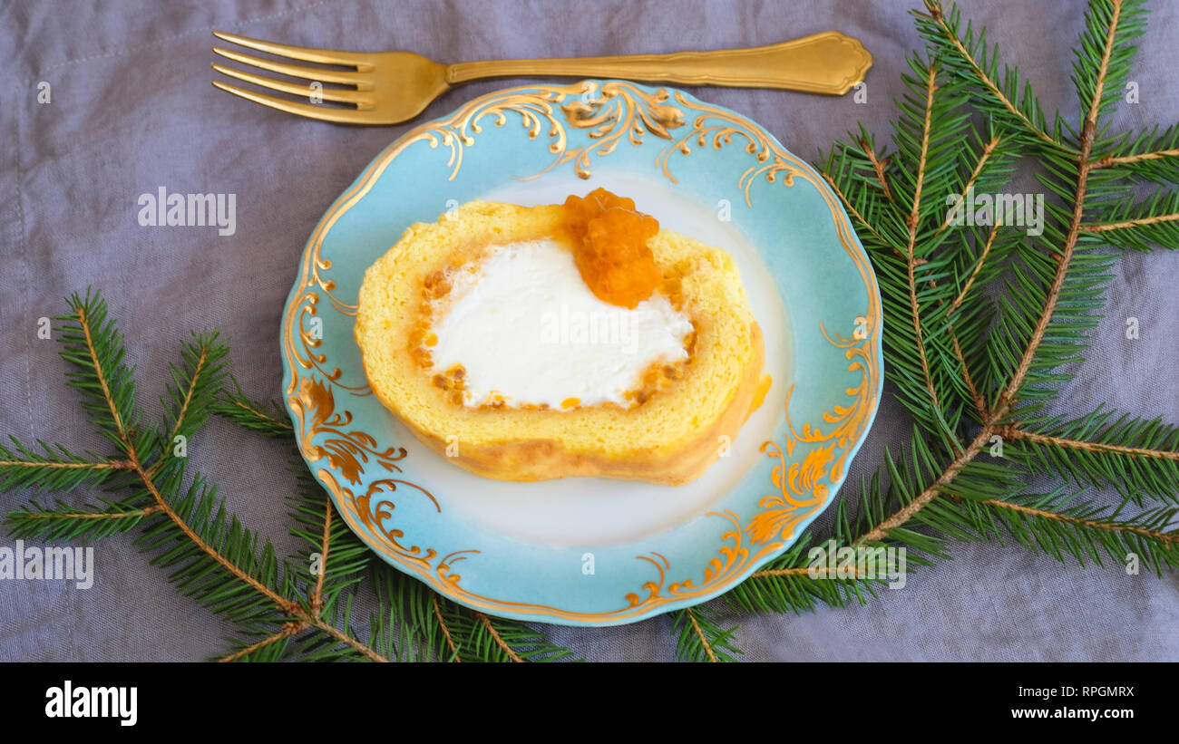 Arctic roll piece on a decorative plate and golden fork . Ice cream ...