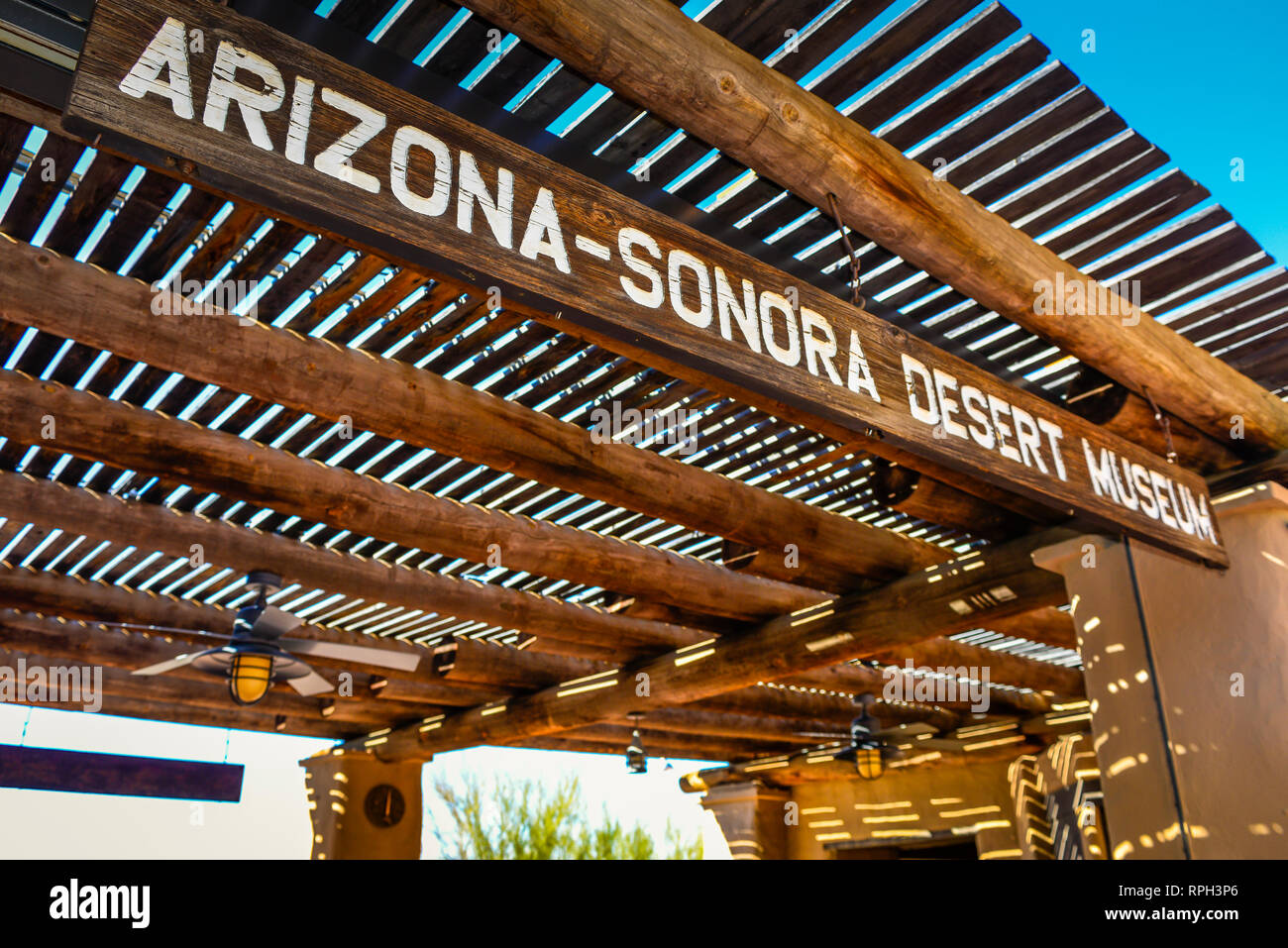 Vistors strollling under the rustic handcarved wooden sign hanging ...