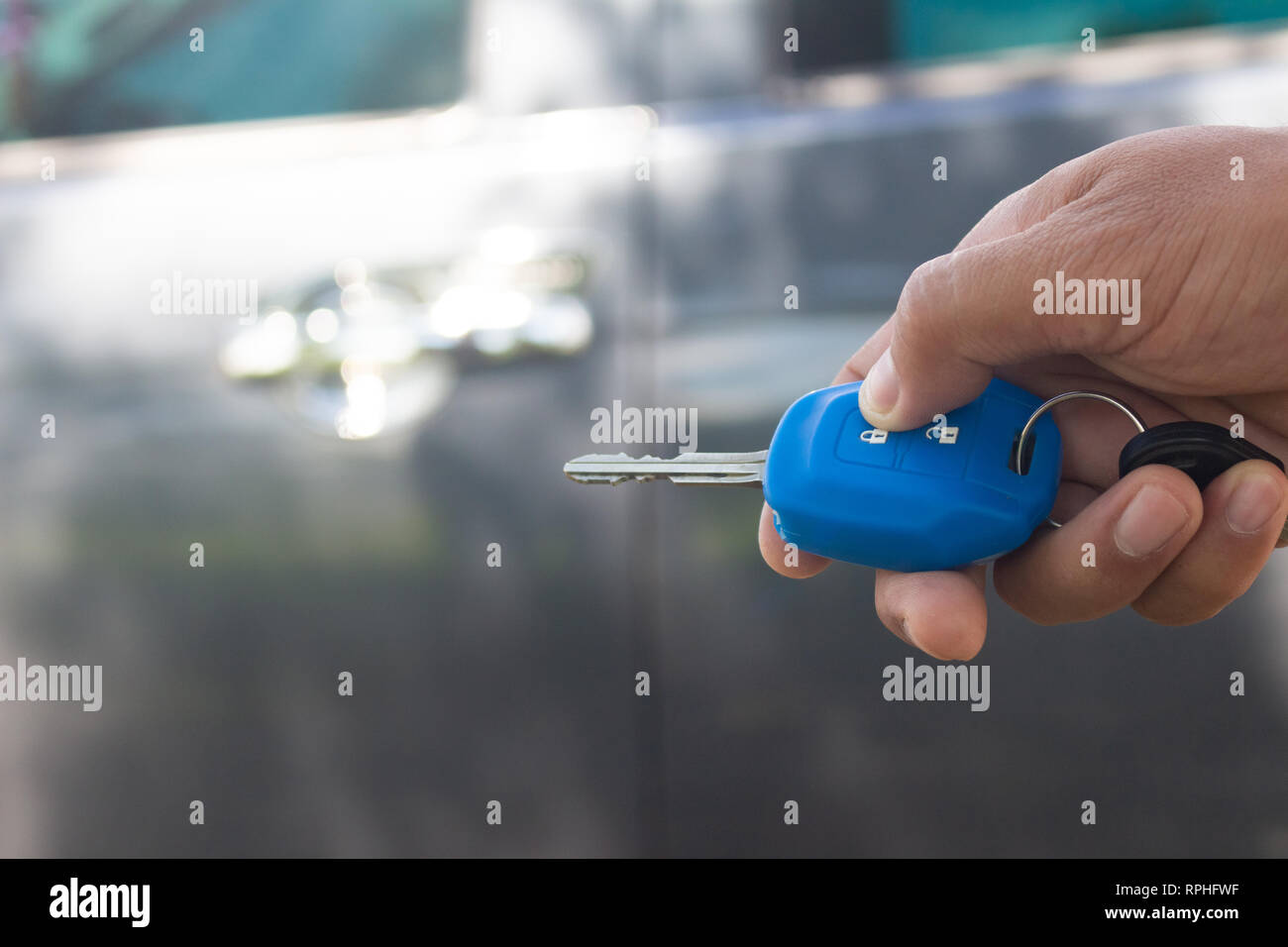 Car blue keys in hand to unlock door Stock Photo - Alamy