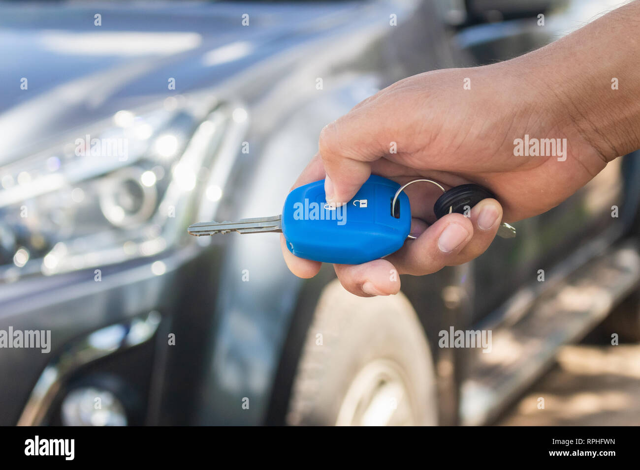Car blue keys in hand to unlock door Stock Photo - Alamy