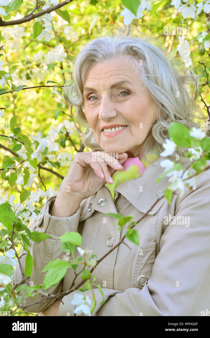 Portrait of beautiful senior woman posing near blooming tree Stock ...