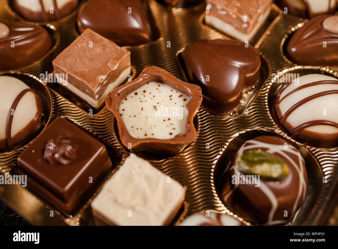 Box of assorted chocolates on black background Stock Photo - Alamy