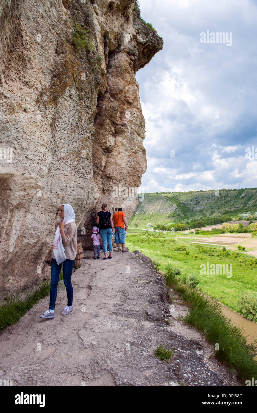 Tourists on the cliff edge outside the Orhei Vechi Cave Monastery in ...