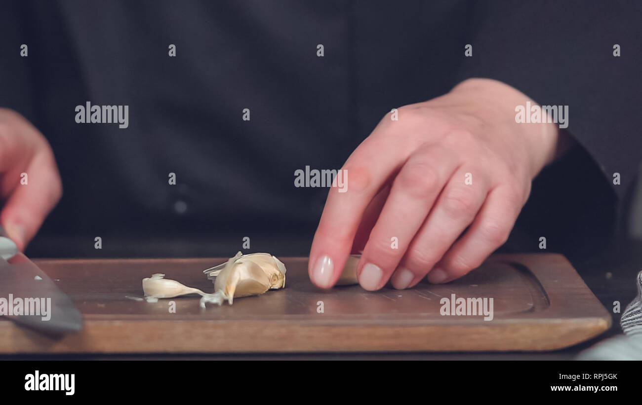 Step by step. Dicing organic garlic on wood cutting board Stock Photo ...