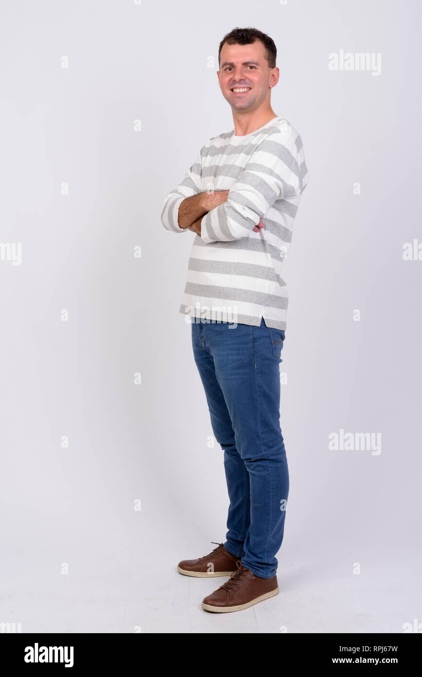 Full body shot profile view of happy man looking at camera with arms ...