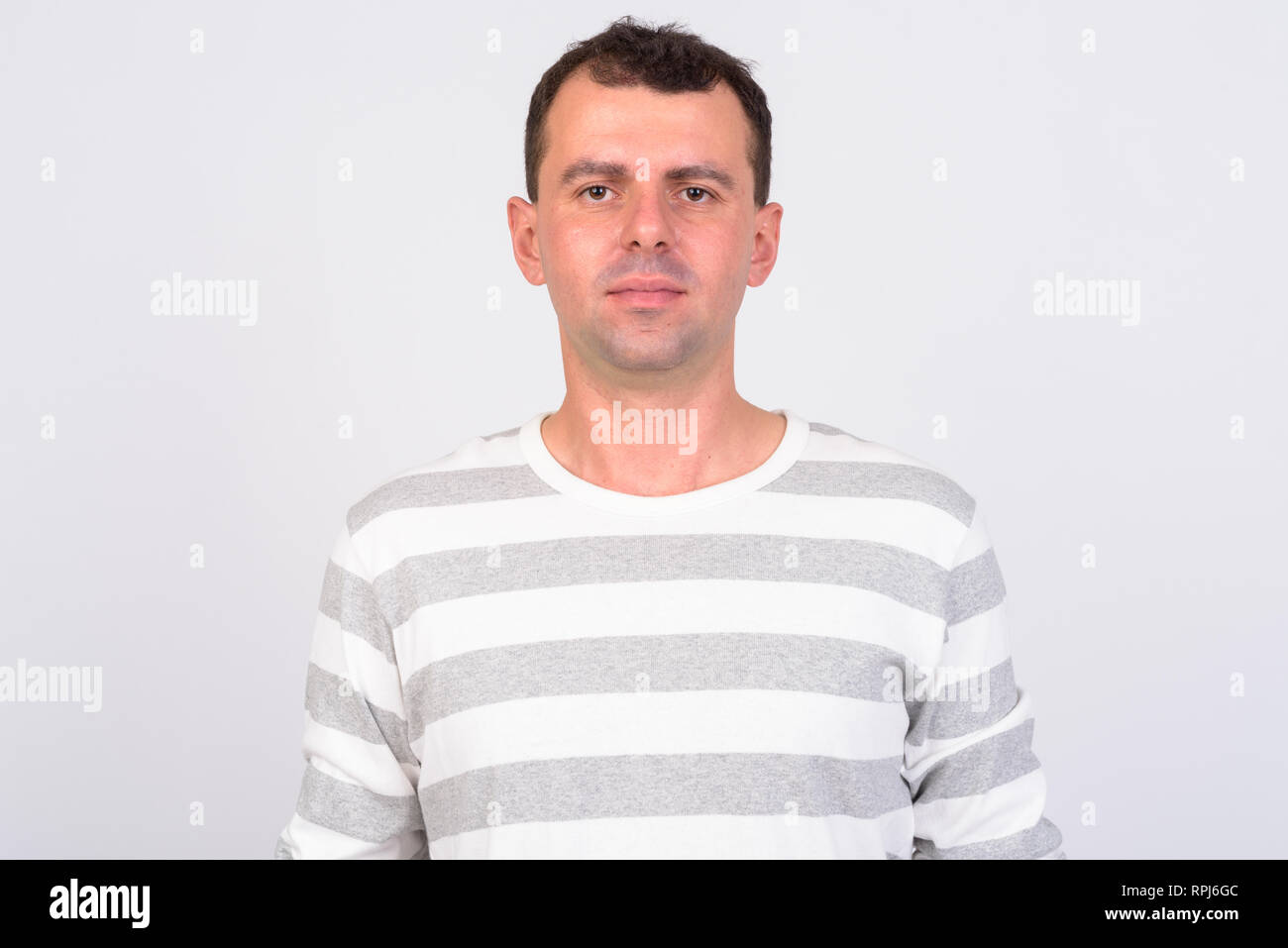 Face of man looking at camera against white background Stock Photo - Alamy