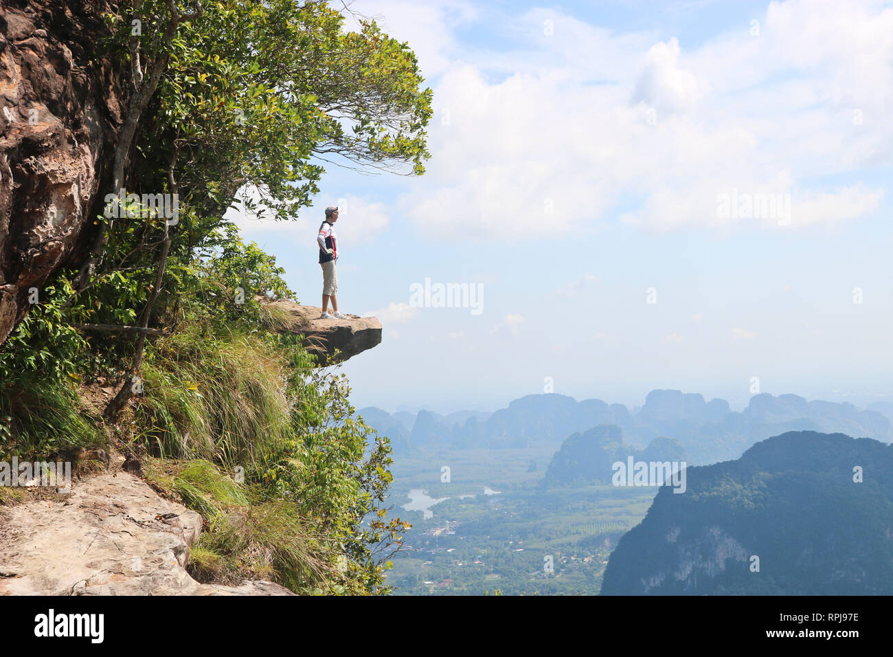 Man standing on cliff ledge hi-res stock photography and images - Alamy