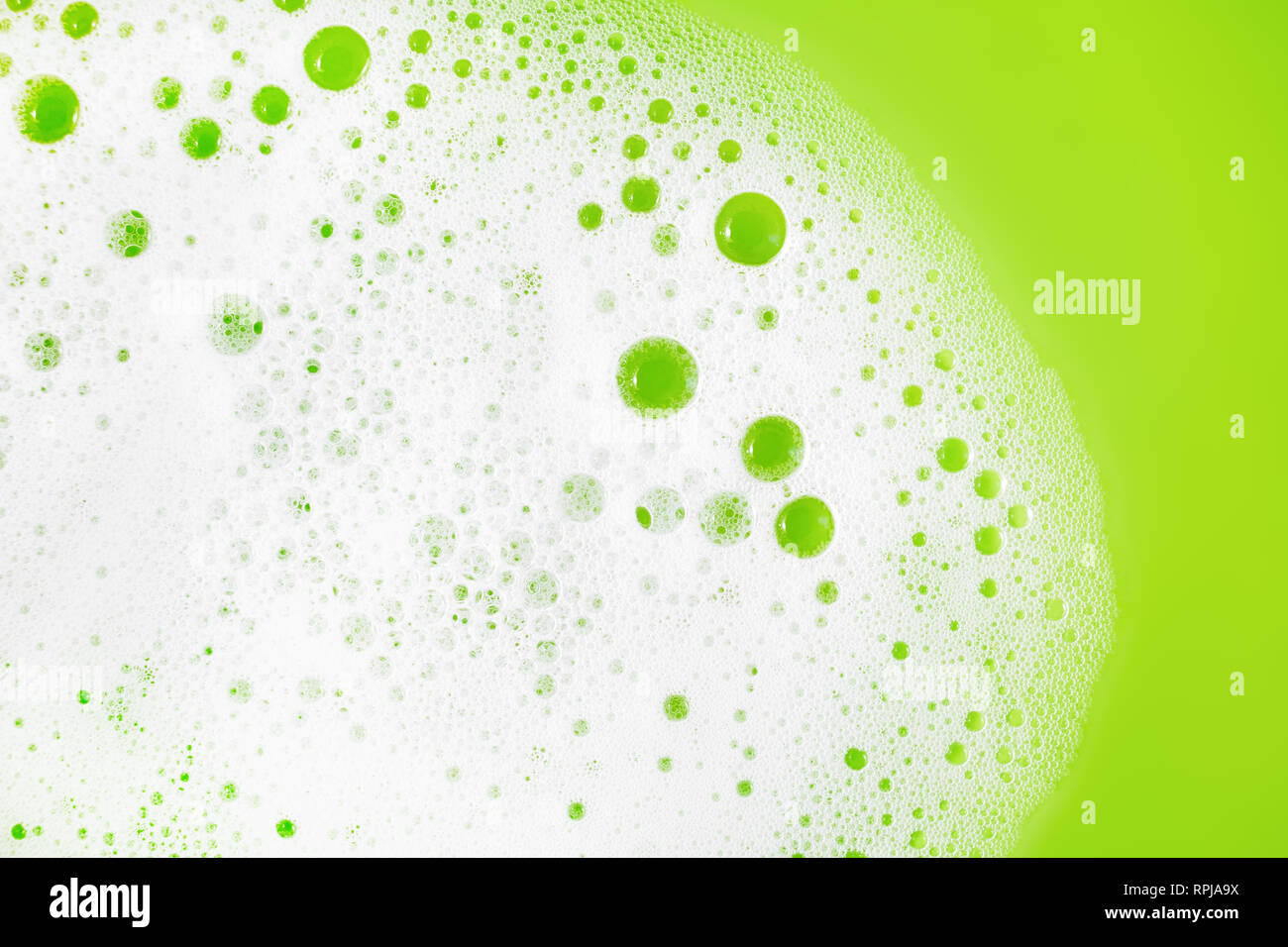 Soap foam with bubbles on green background. Soap sud in water ...