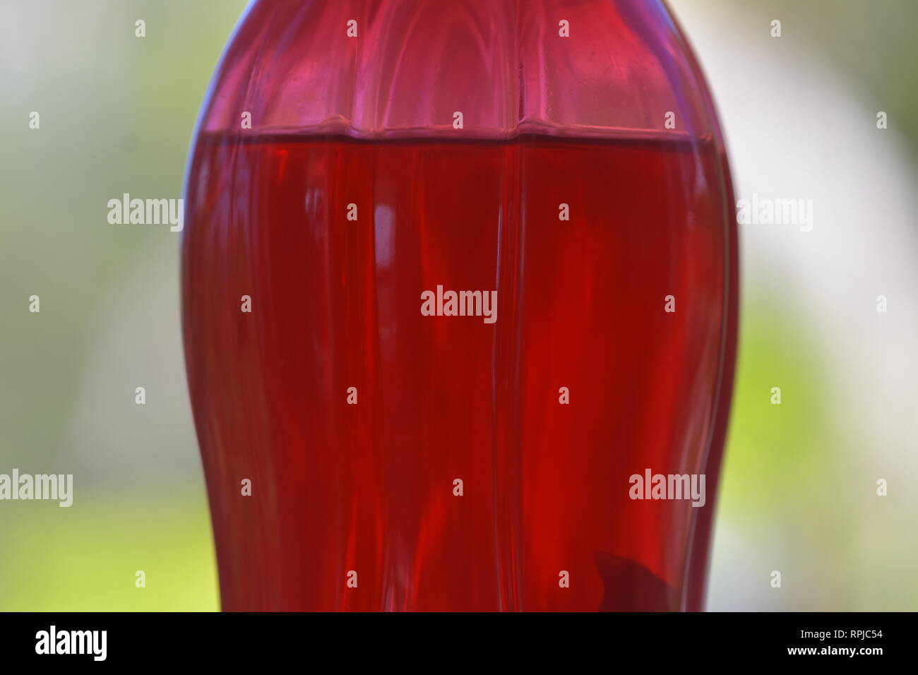 Detail of red plastic translucent drinking bottle with strengthening ...