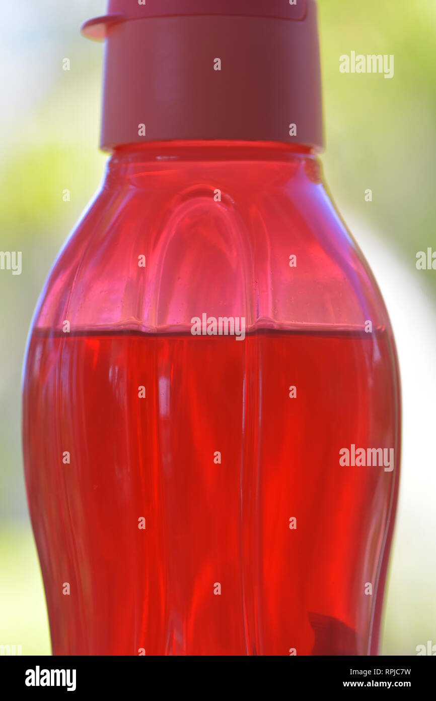 Red plastic translucent drinking bottle with red lid and strengthening ...