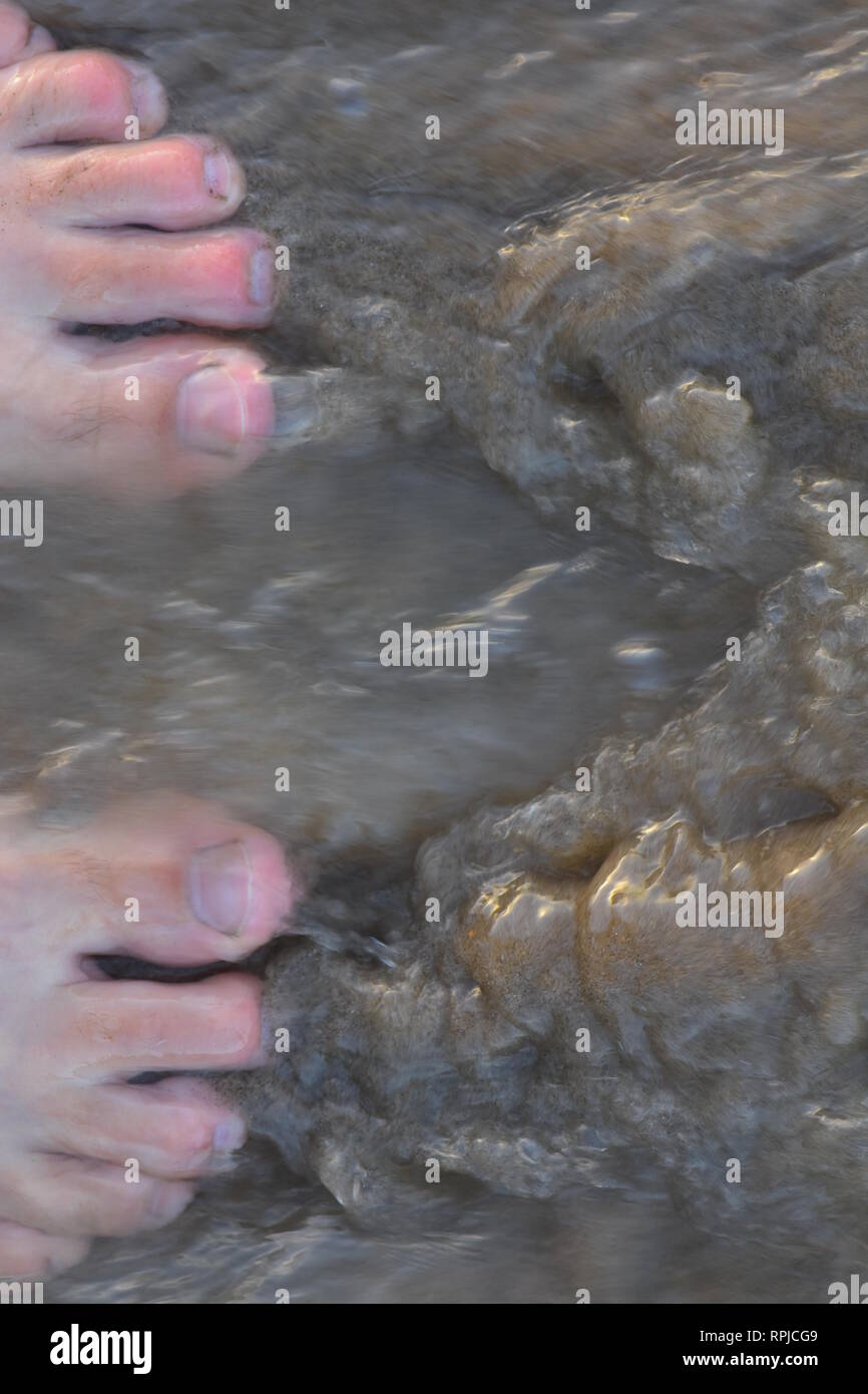 Water flowing over fine beach sand and human toes Stock Photo - Alamy
