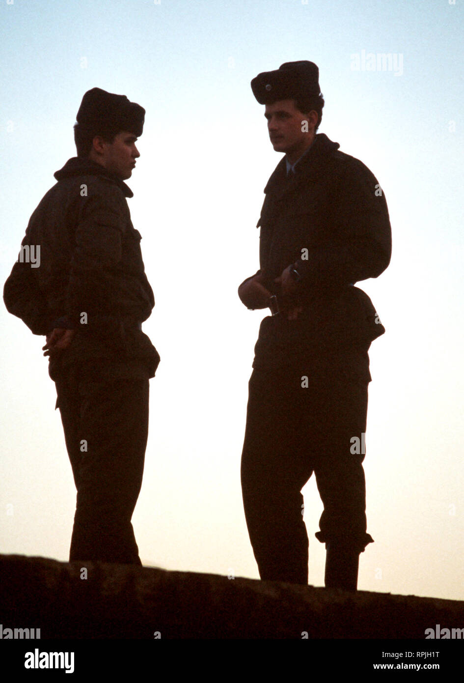 East German guards stand atop the Berlin Wall beside the Brandenburg ...