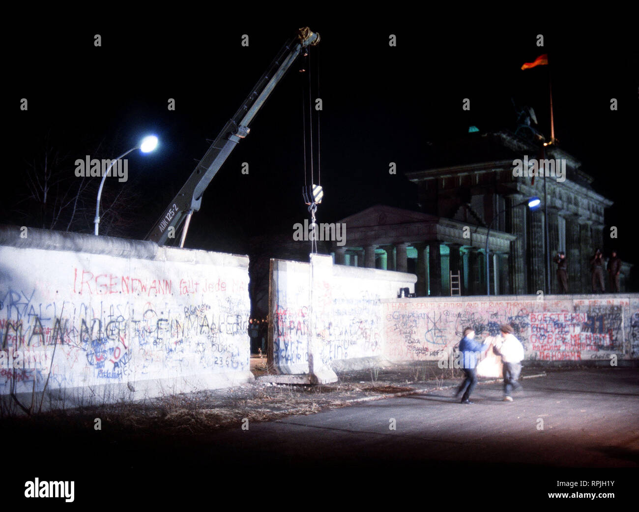 Local residents rejoice as a crane removes a section of the Berlin Wall ...